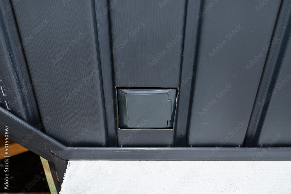 A modern graphite soffit with a hidden electrical socket is attached to ...