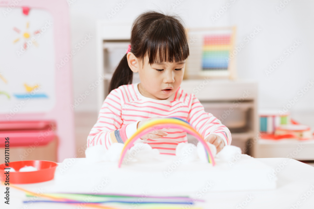 young girl making rainbow craft using pipe cleaner at home Stock Photo ...