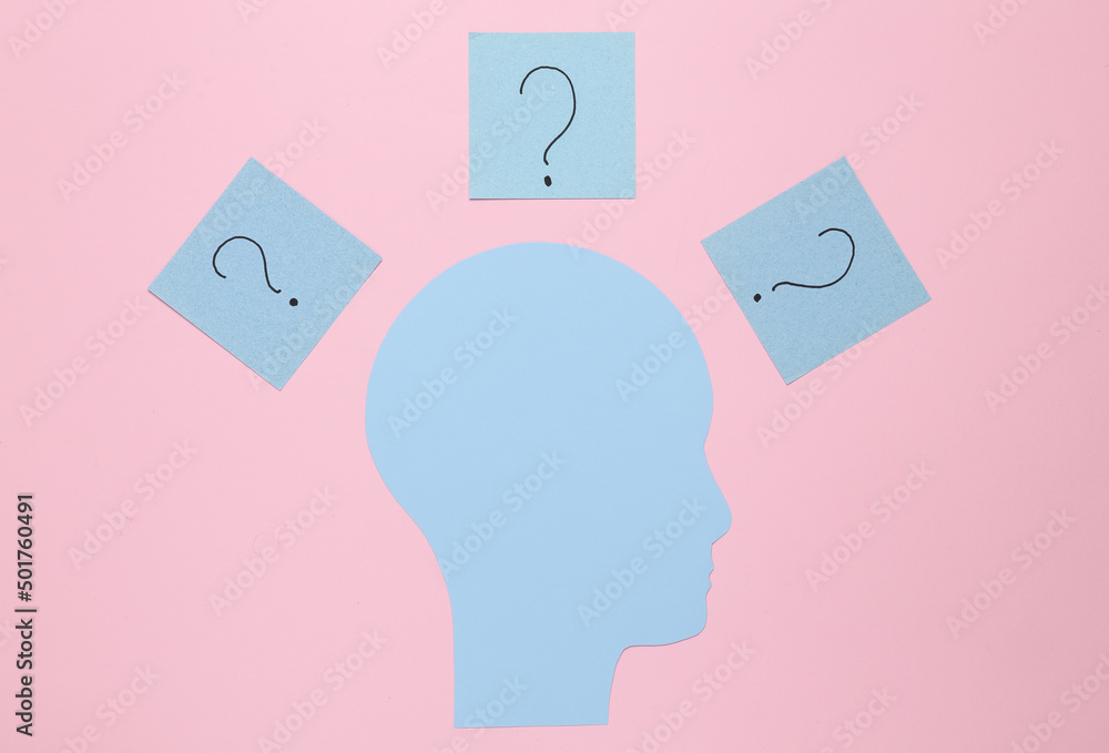 Paper cut head and memo papers with question marks on pink background ...