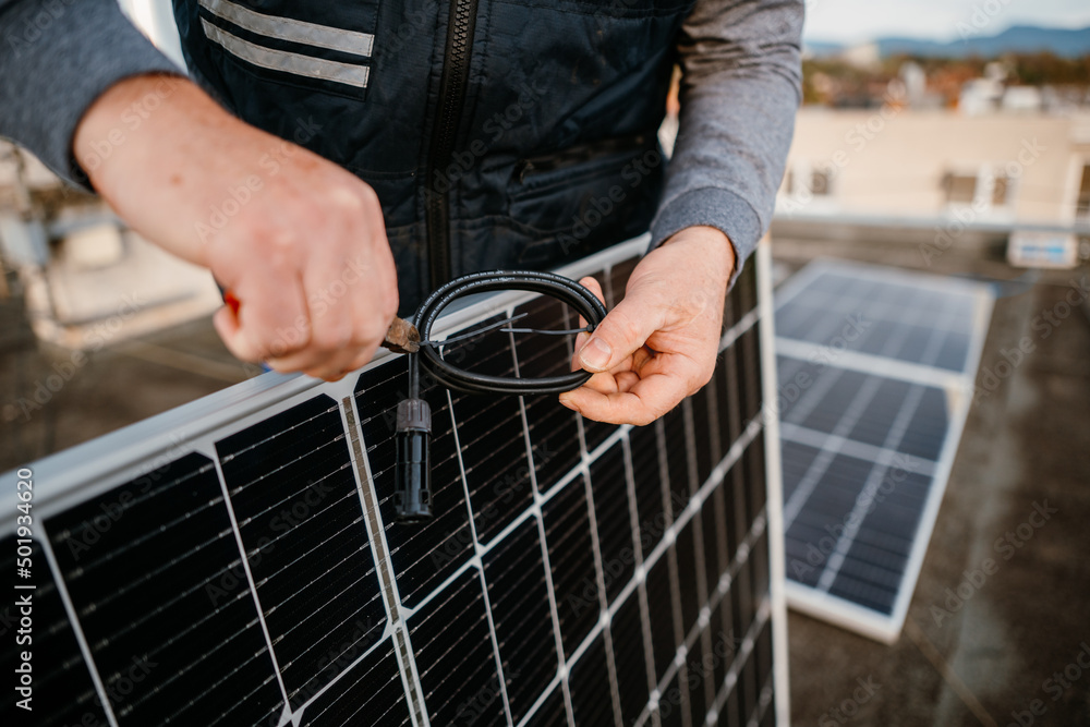 Worker installing new solar panels. Worker hold connect cable Stock ...