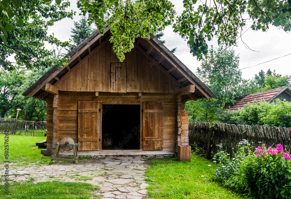 vintage rural barn with grinding wheel on farmyard in reconstruction of ...