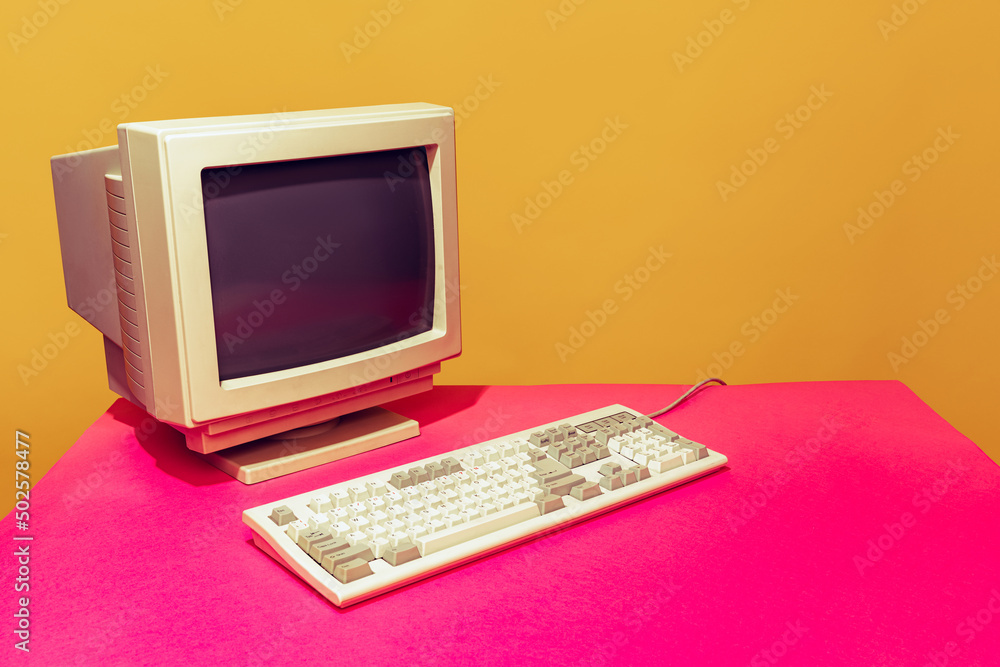 Colorful image of vintage computer monitor and keyboard on bright pink ...