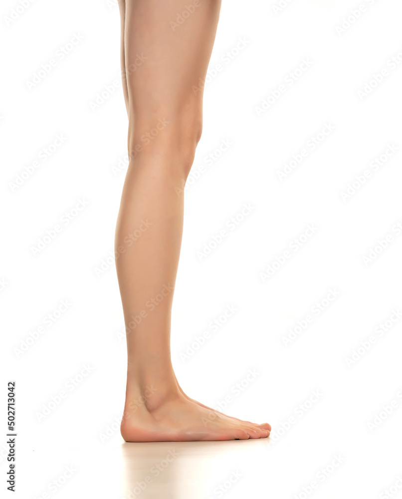 Side view of beautifully cared women's legs and feet on white ...