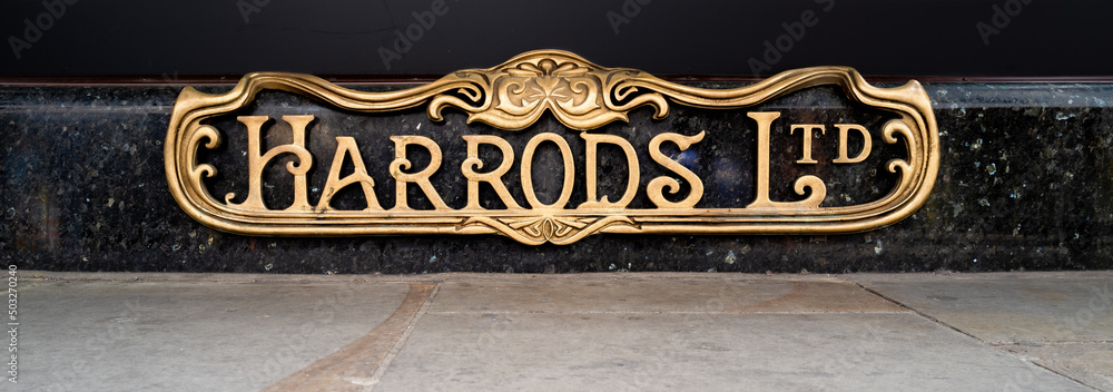 Art deco brass Harrods sign, at pavement level, on the exterior of the ...