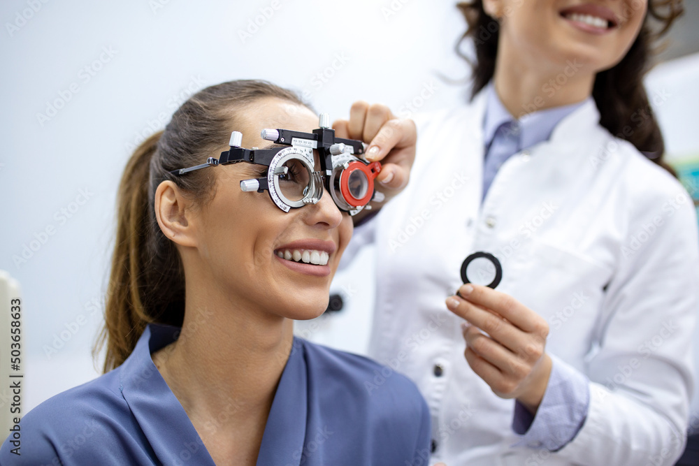 Ophthalmologist examining woman with optometrist trial frame. female ...