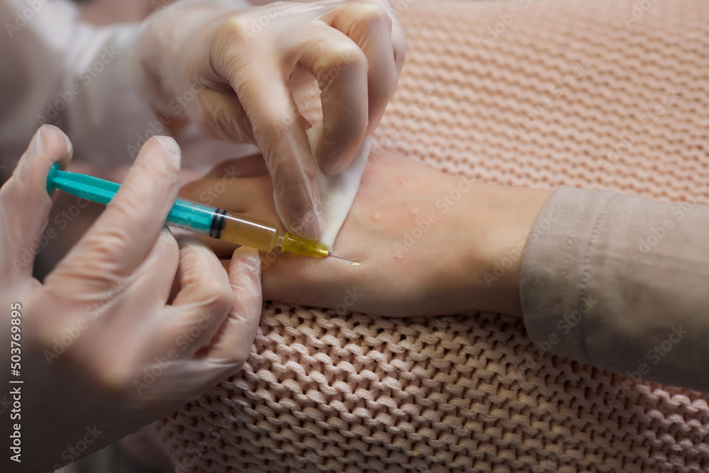 Doctor doing stem cell therapy on a patient's elbow after the injury. Treating knee pain with ...