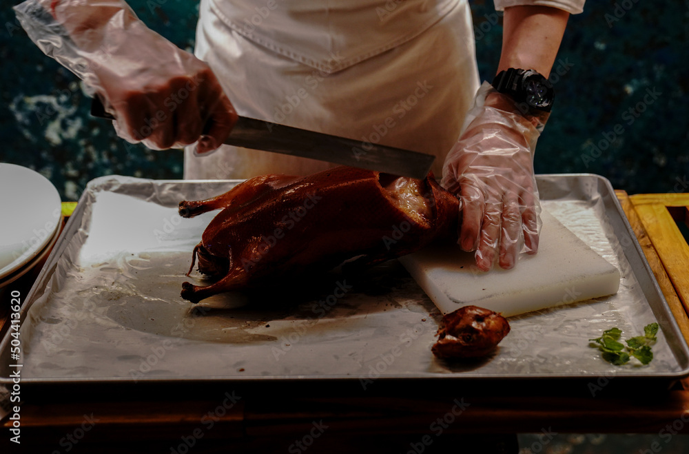 Chinese cook prepares Peking Roast Duck. Peking Duck is a famous duck ...