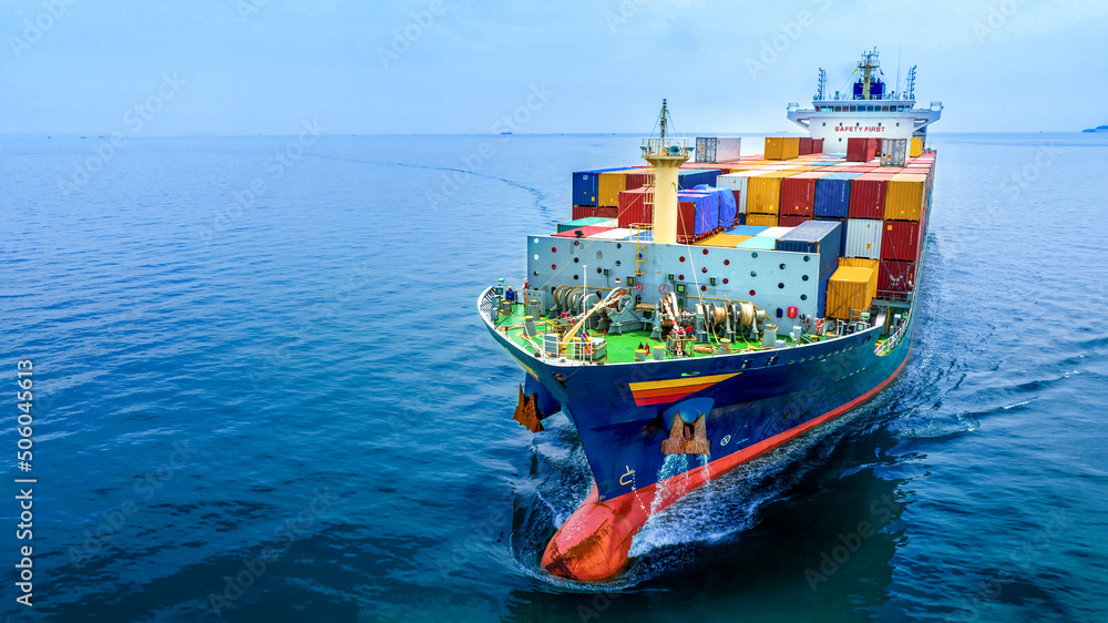 Aerial side view of cargo ship carrying container and running for ...