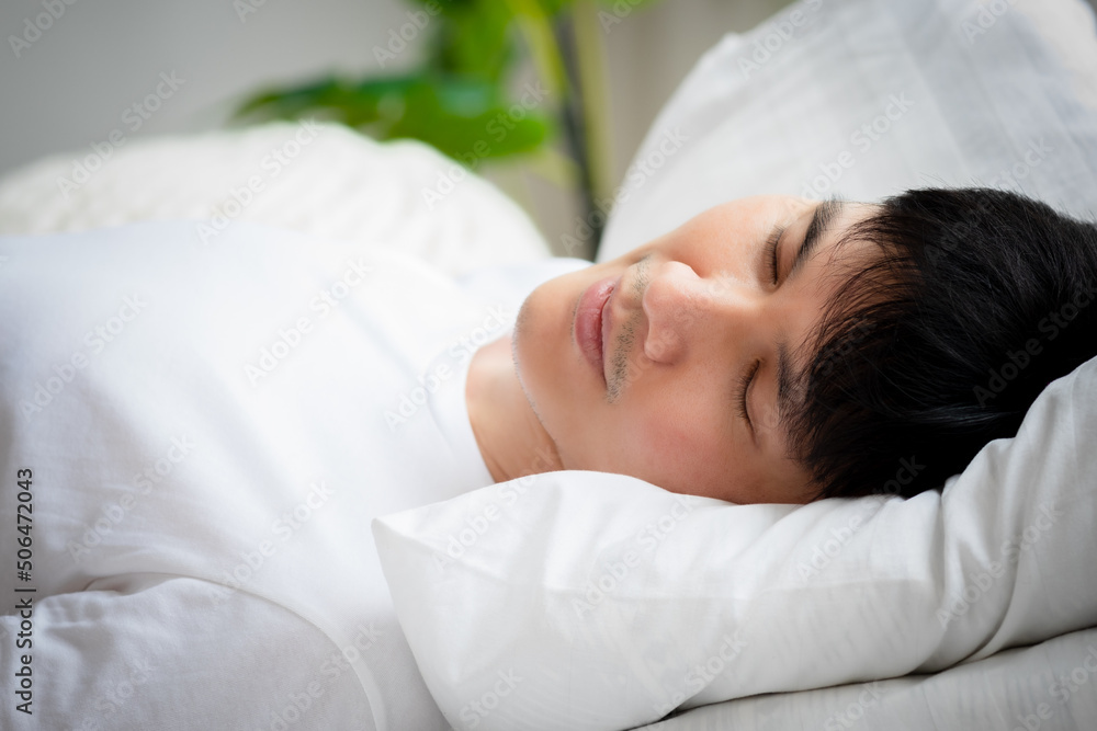 Handsome Asian man sleeping on bed until morning Young guy sleep well ...