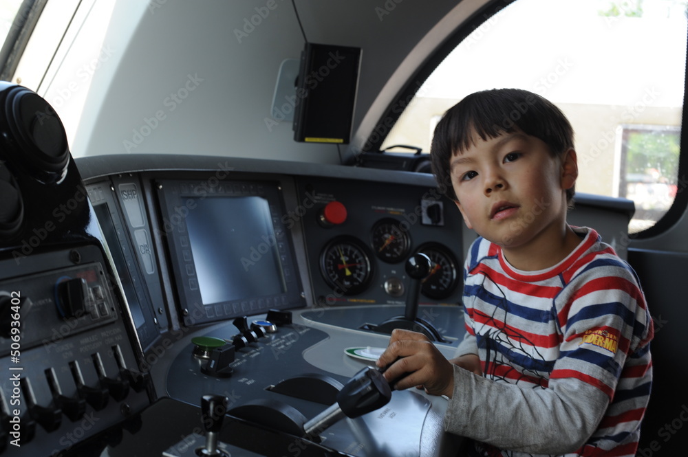 Foto A young boy steering a locomotive and train in a driving ...