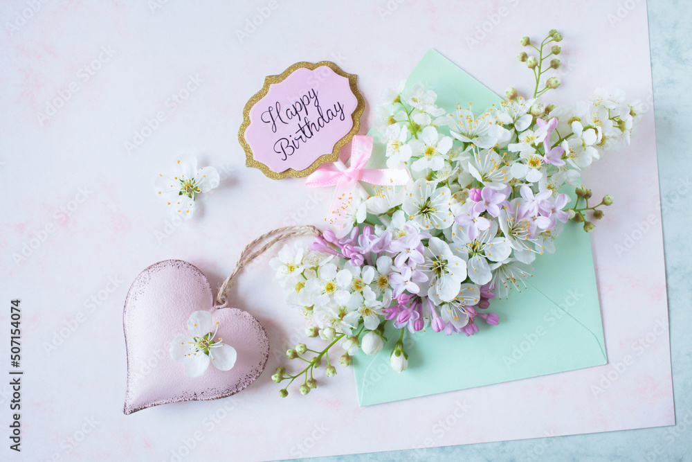 Birthday card. An envelope with spring flowers, a heart and nameplate ...