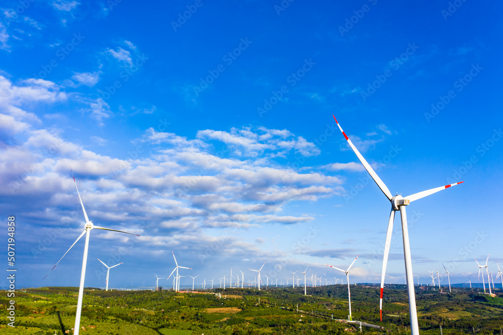 Wind turbine towers farm in a big field to generate electricity. Clean ...