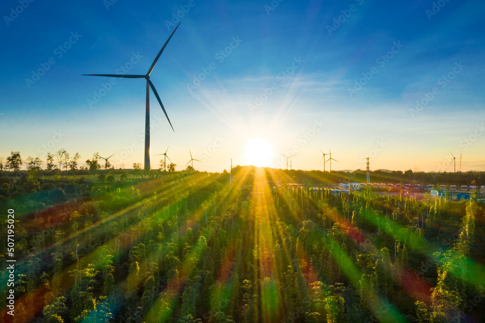 Wind turbine towers farm in a big field to generate electricity. Clean ...