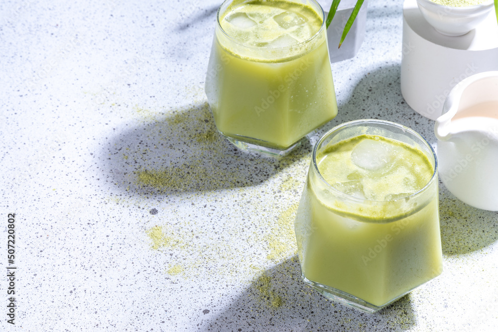 Cold matcha green tea drink. Iced matcha latte cocktail in two glasses ...