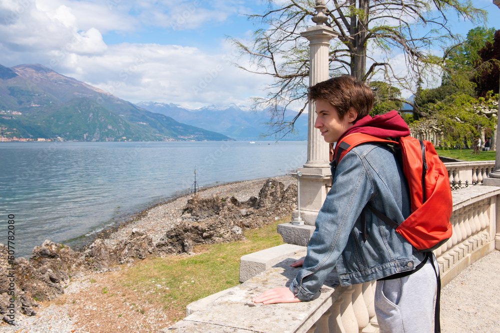 Handsome teen boy walking at park with great view at landscape with ...