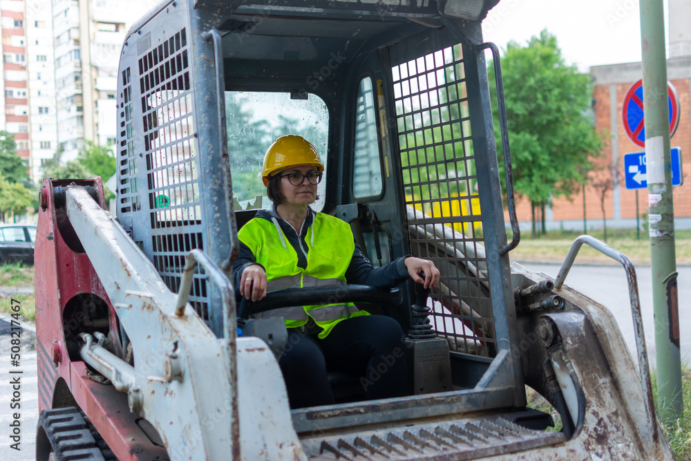 Cheerful female excavator operator on construction site. Woman ...
