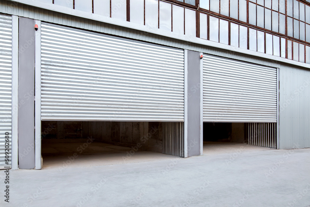 Opening gray iron shutter door of garage and industrial building ...