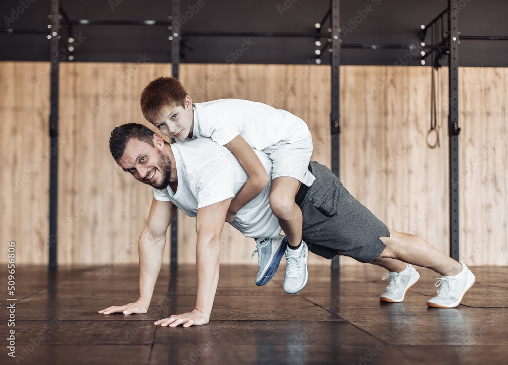 The concept of a healthy family. Father coach doing push-ups with his ...