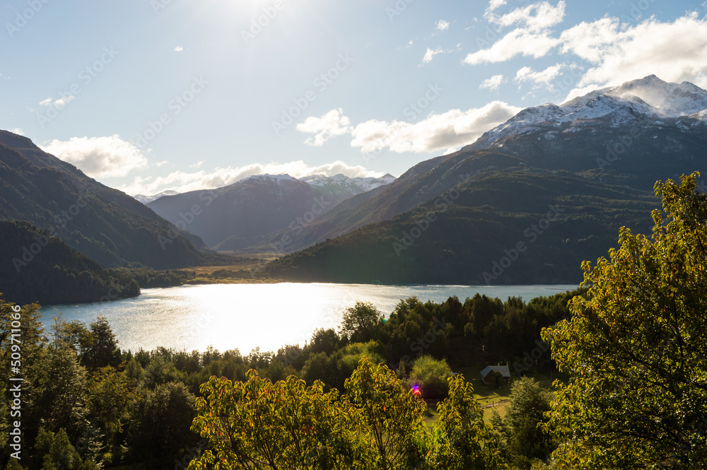 Lake between mountains of the Andes mountain range and a rustic house ...