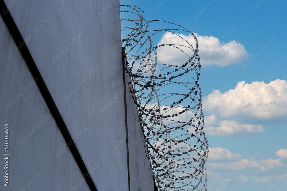 Foto de Stock high concrete fence, barbed wire fence on top, pre-trial ...