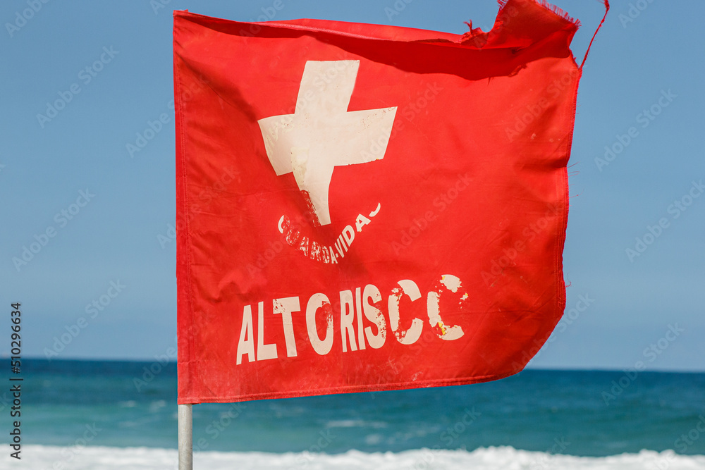 red current signaling flag, written high risk on a beach in Rio de ...