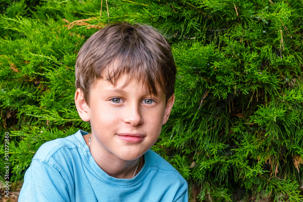 A 9-year-old boy smiles skeptically while looking at the camera ...