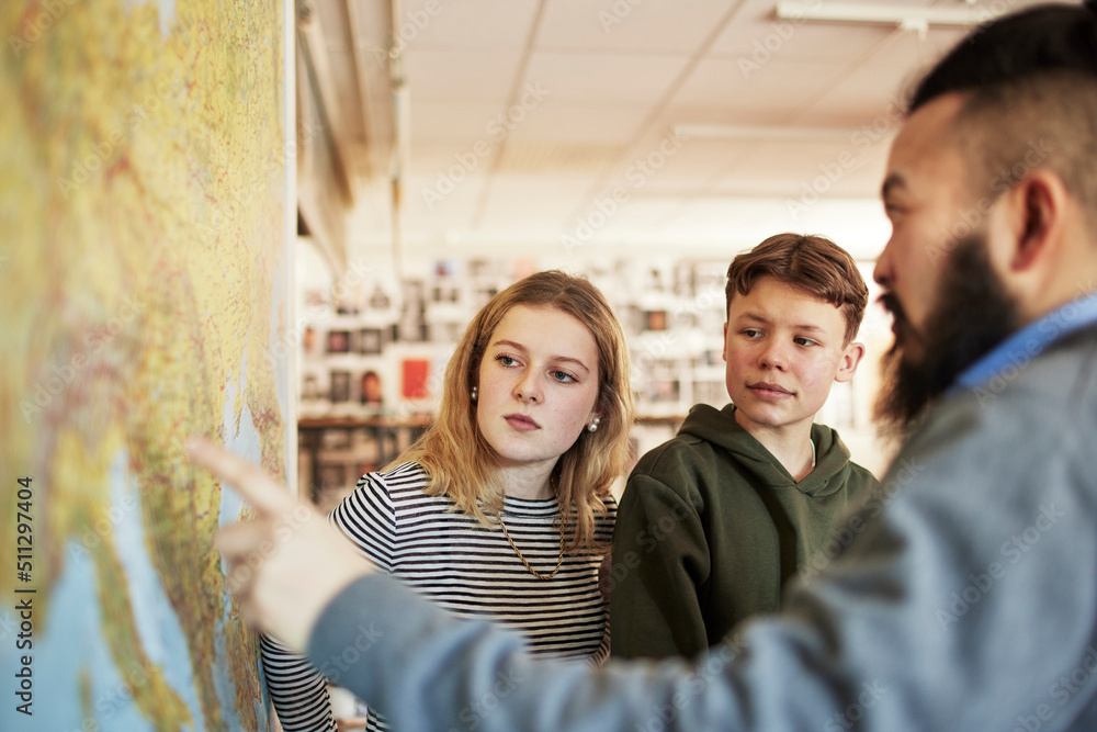 Students and teacher examining map in class Stock Photo | Adobe Stock