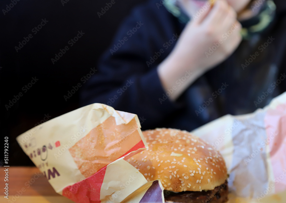 Person eating a Whopper burger with fries from Burger King. Burger King ...