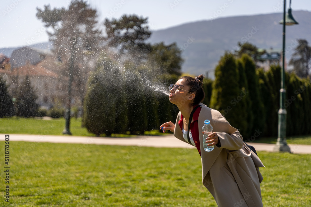 Stock-Foto „Young girl spitting water out from her mouth“ | Adobe Stock