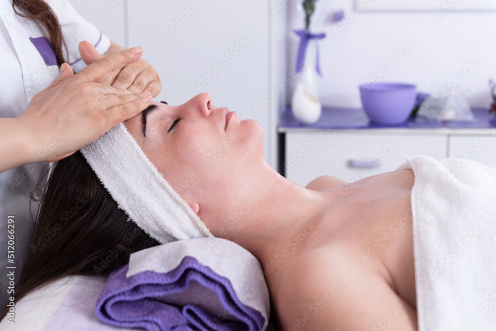 Esthetician performing professional facial massage on woman's face in ...