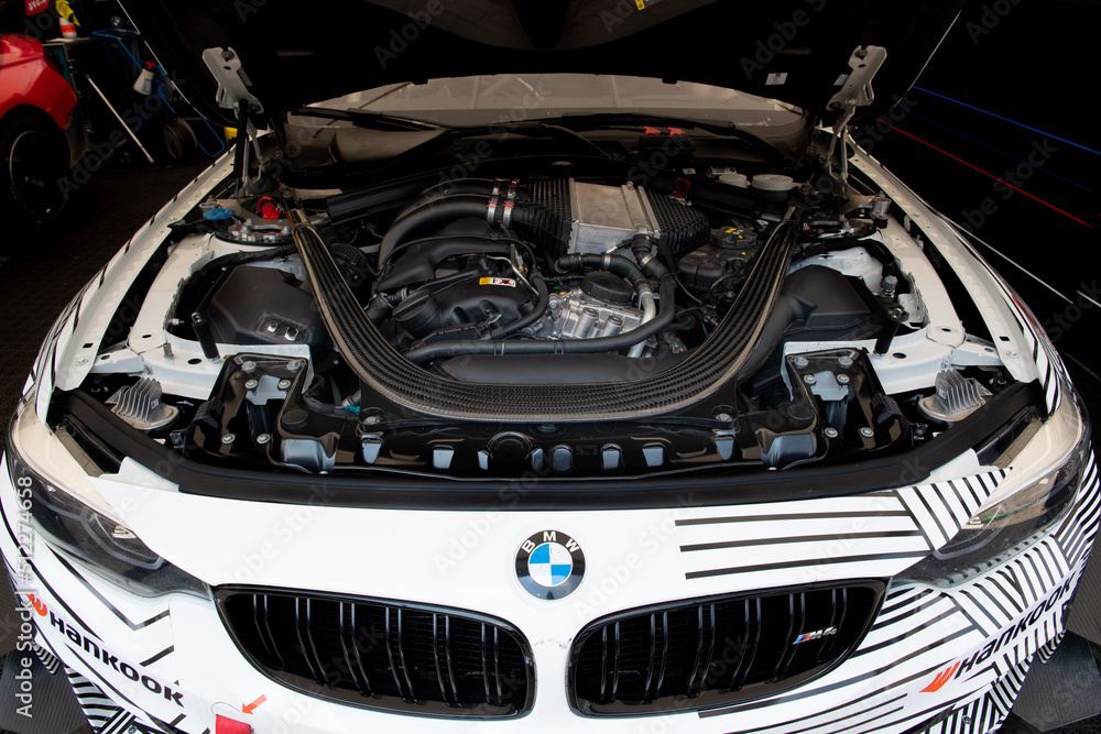 BMW M4 GT racing super car in box circuit, open hood and visible engine ...