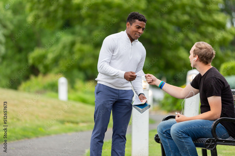 Young man handing out a gospel tract Stock Photo | Adobe Stock