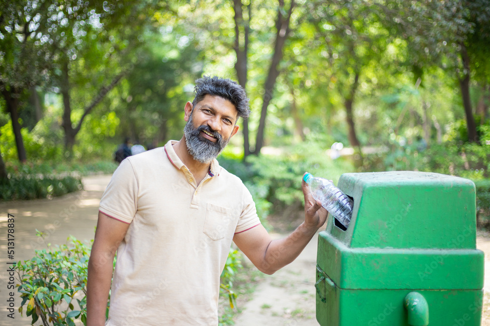 Indian man throw plastic bottle in recycling garbage bin, pollution or ...