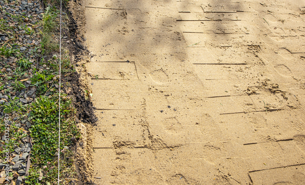 The boundary between wet sand and crushed stone with pebbles on the ...