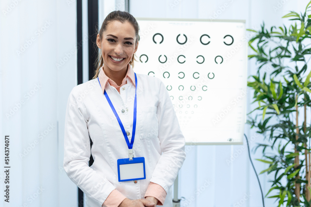 Professional female optician pointing at eye chart, timely diagnosis of ...
