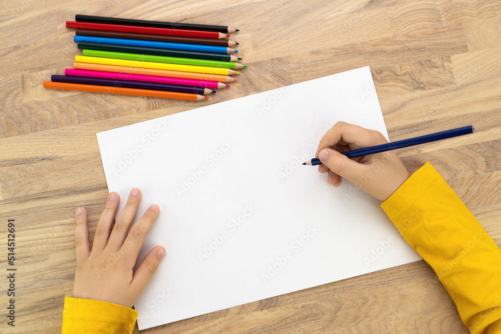 Child hands drawing with pencil on white paper, top view. Kids painting ...