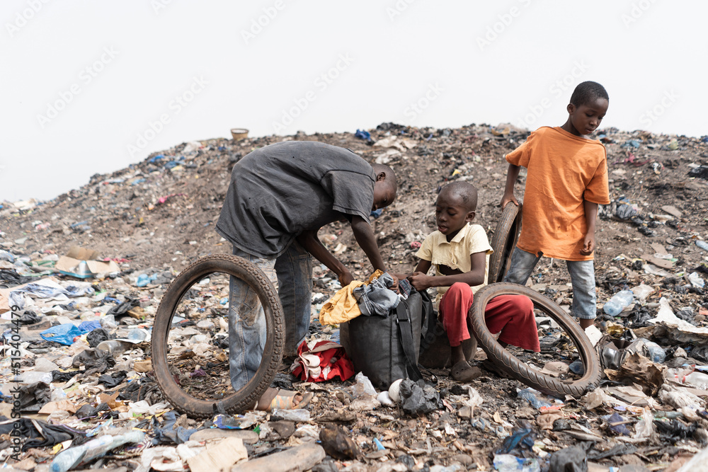 Three homeless street boys in a landfill with their daily loot of ...