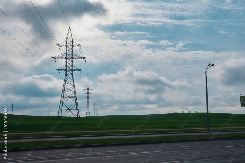 High voltage electric pylon and electrical wire at green rice field and ...