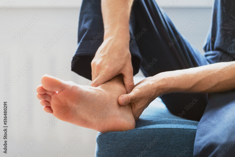 Ankle sprain. Man hold his sprained ankle after injury. Sprained and ...