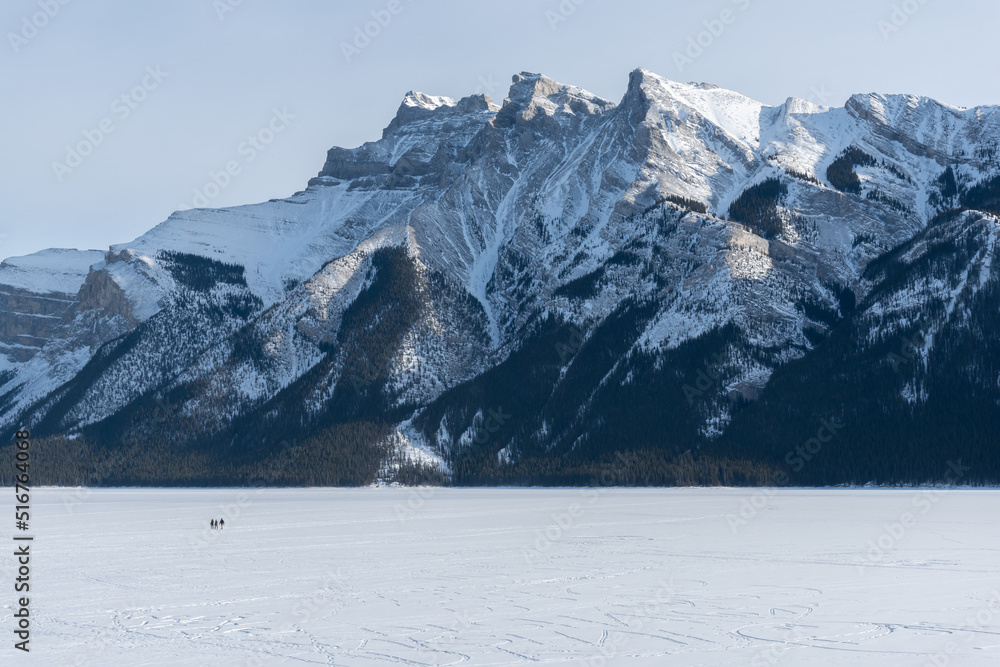 Enormous mountain and ice covered lake Minnewanka with silhouette of ...