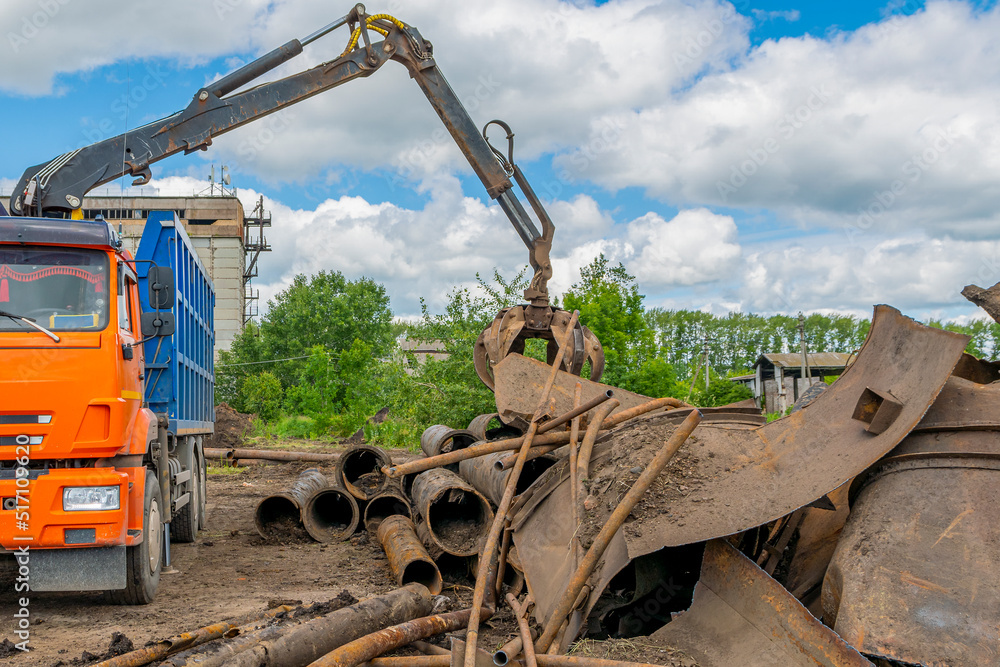 Hydraulic arm of grapple manipulator grabs scrap metal for loading into ...