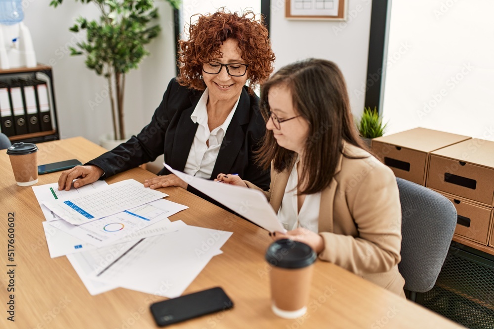Group of two women working at the office. Mature woman and down ...