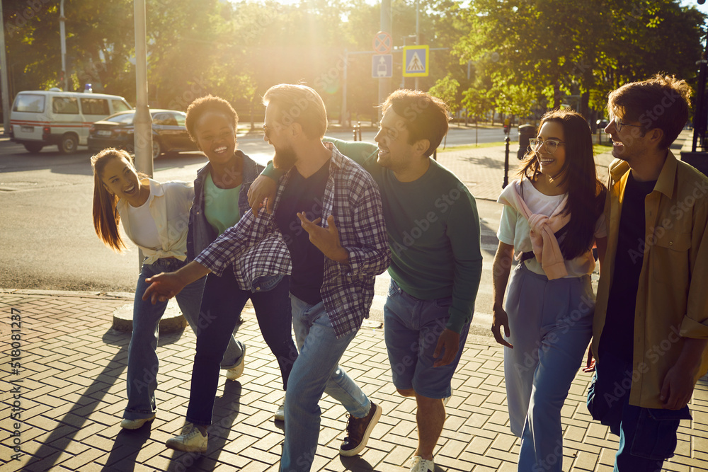 Exploring city together. Goup of cheerful friends walk streets of new ...