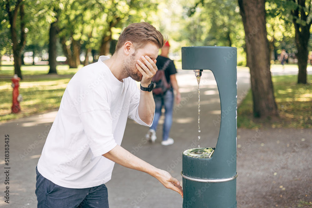 Man refilling his water bottle at the city. Free public water bottle ...