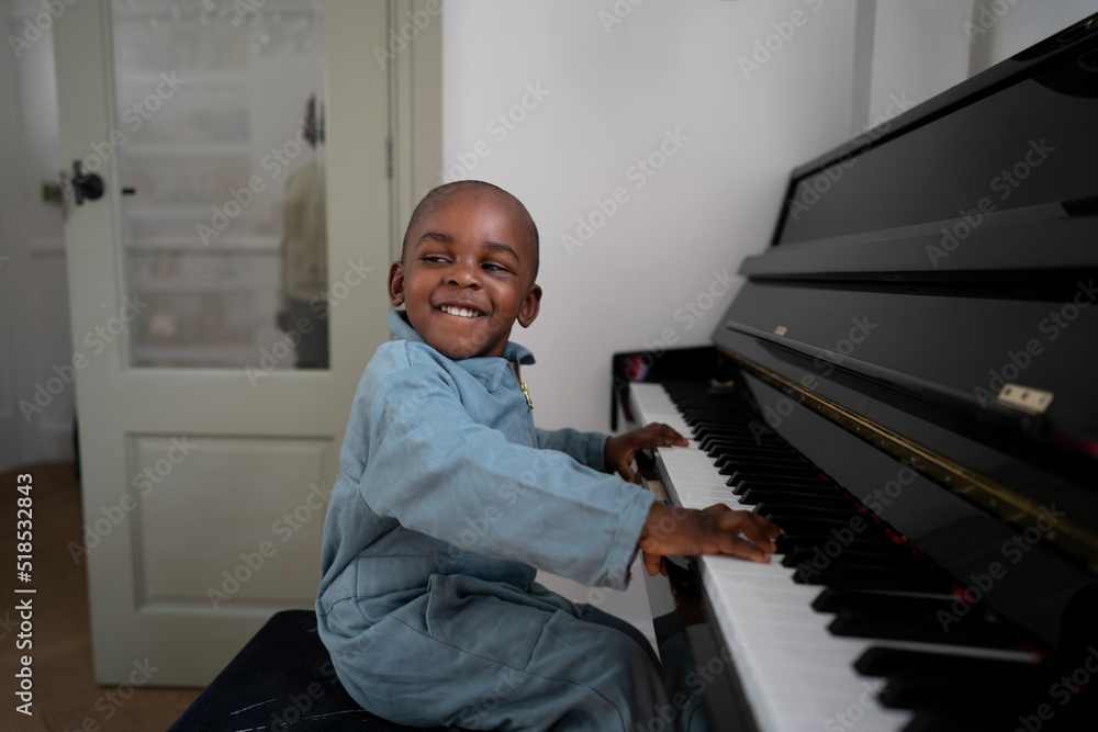 Smiling boy (2-3) playing piano Stock Photo | Adobe Stock
