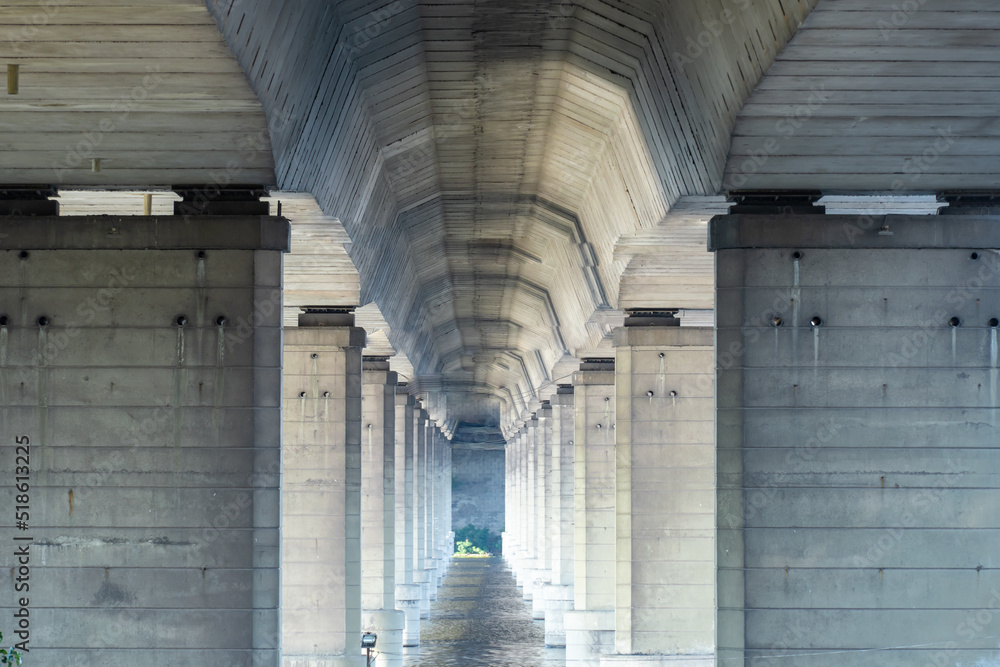 Tunnel from column under road bridge in city. Row pillars and group ...