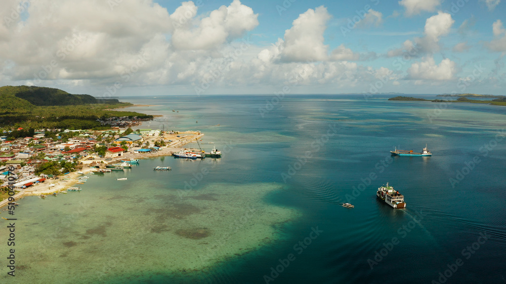 Passenger port with ferries and cargo ships on the island of Siargao ...