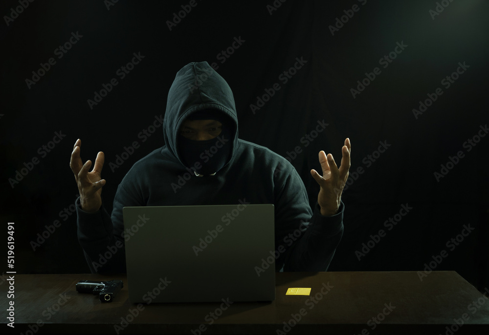 hacker hacking fail at night, stress man in black hoodie having a gun ...