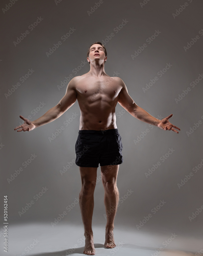 young muscular man in an expressive pose, artistic pose of the hero ...