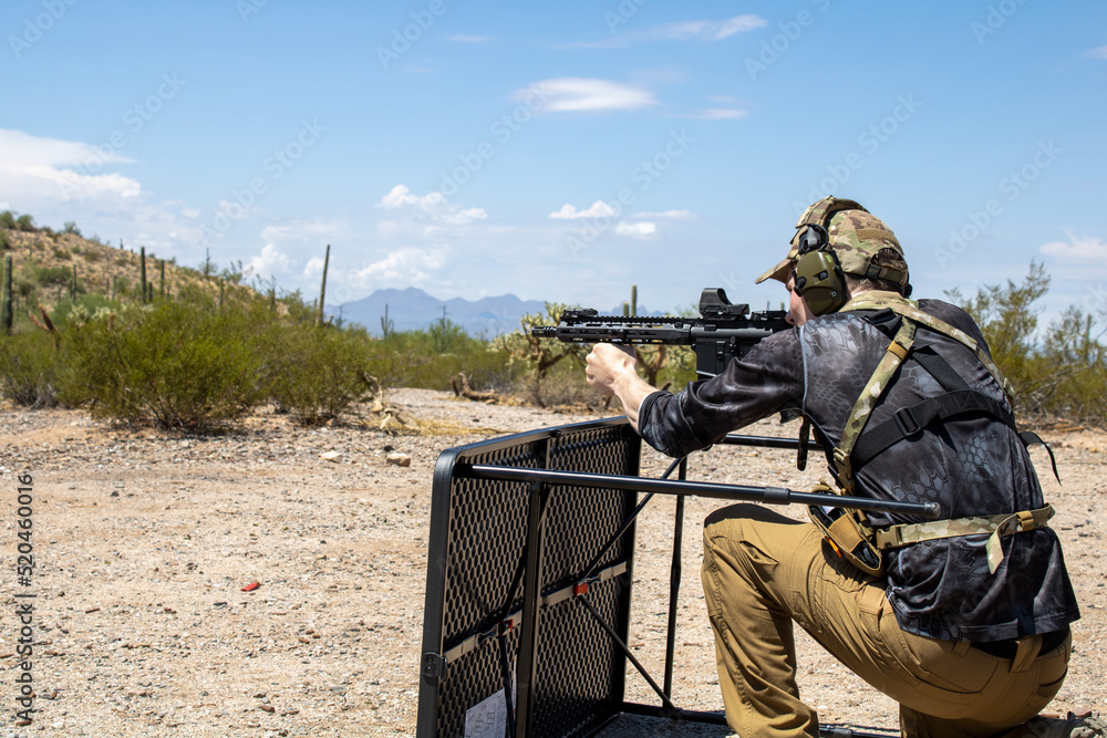 Male holding ar15 pistol with vertical foregrip and holosight and ...